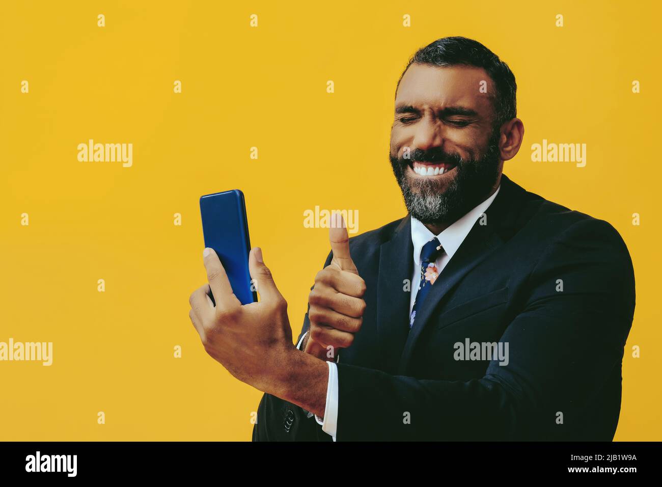 portrait of smiling positive handsome bearded man in suit and tie with ...