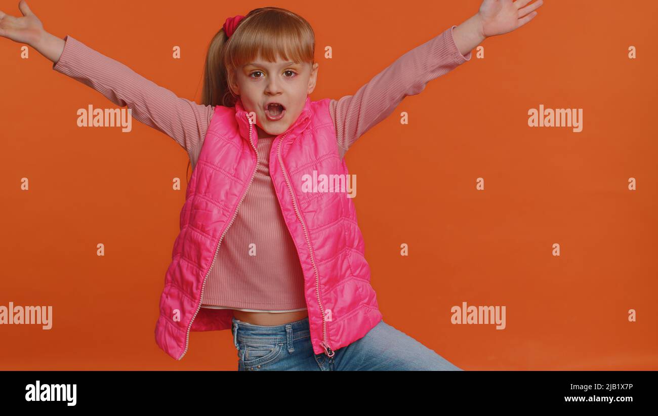 Funny happy sincere little girl 6 years old in vest making playful ...