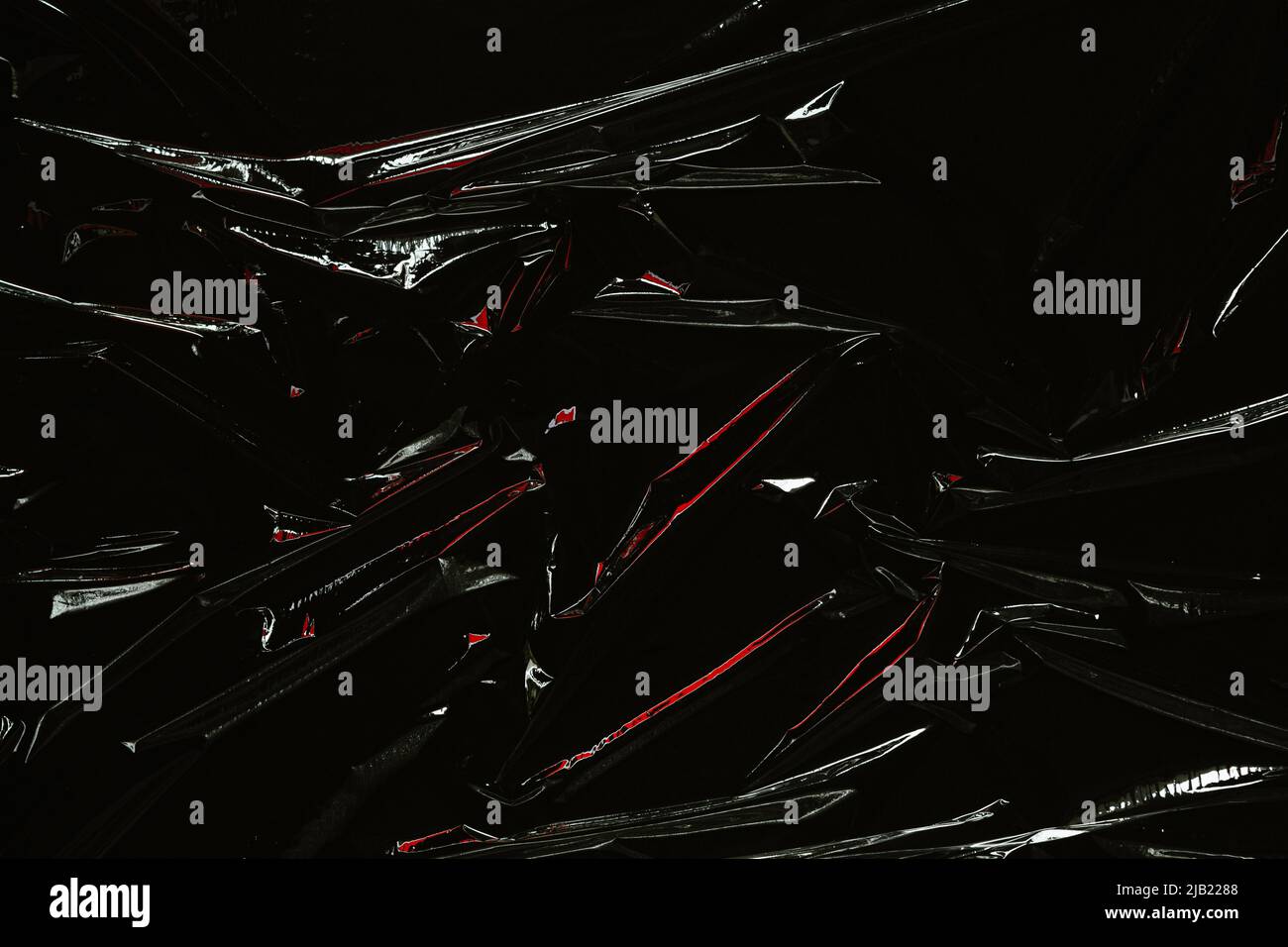 Transparent plastic wrap on black background. Crumpled wrinkled plastic ...