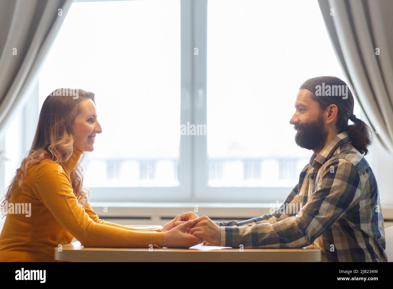 Beautiful couple having a conversation while looking at each other over ...