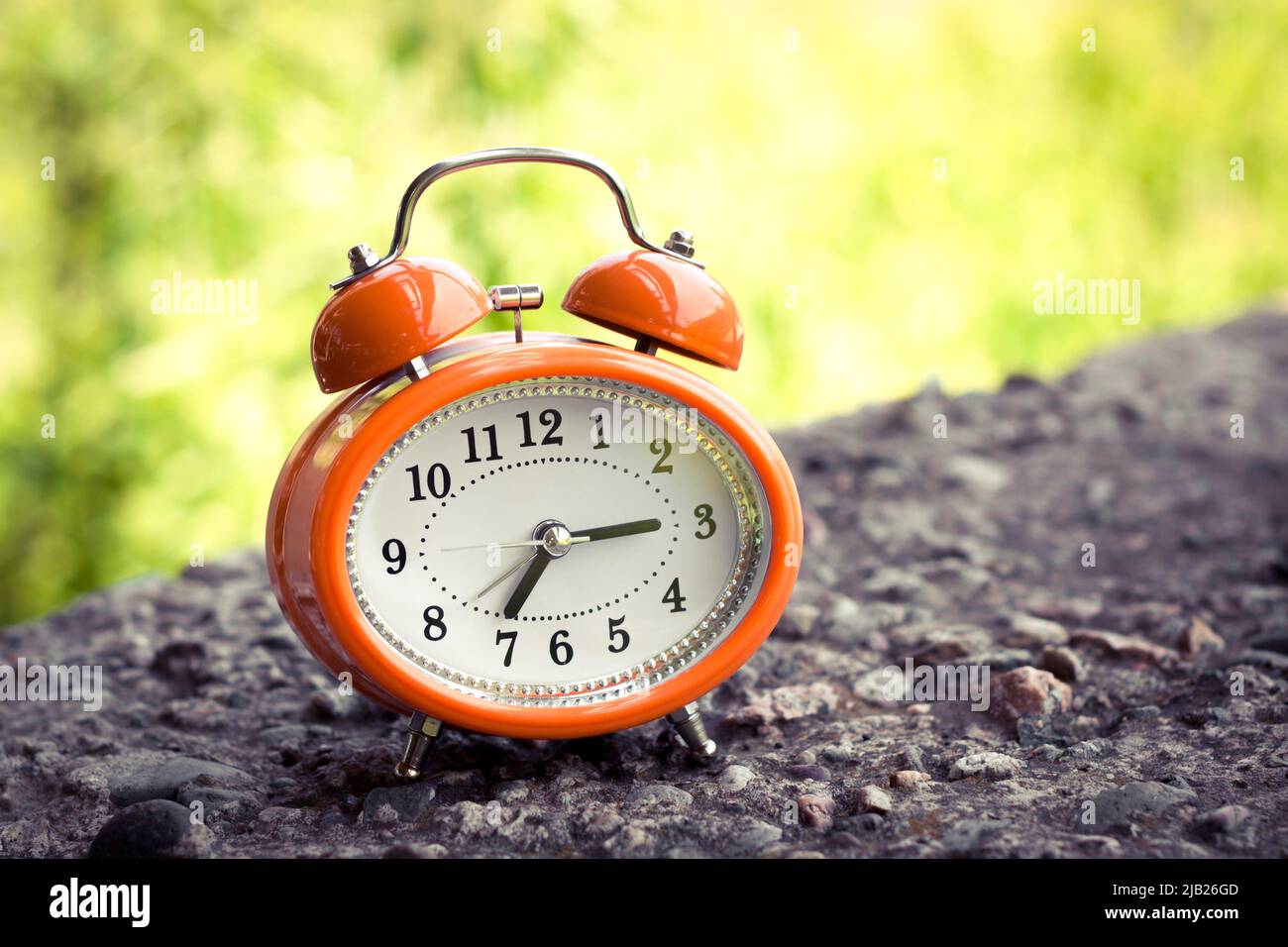 Vintage style orange alarm clock on a concrete surface Stock Photo - Alamy