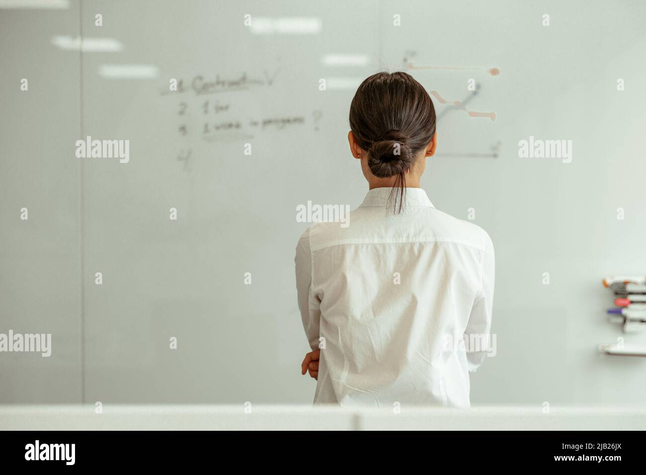 Business woman looks at flipboard with charts and plans. View from the ...