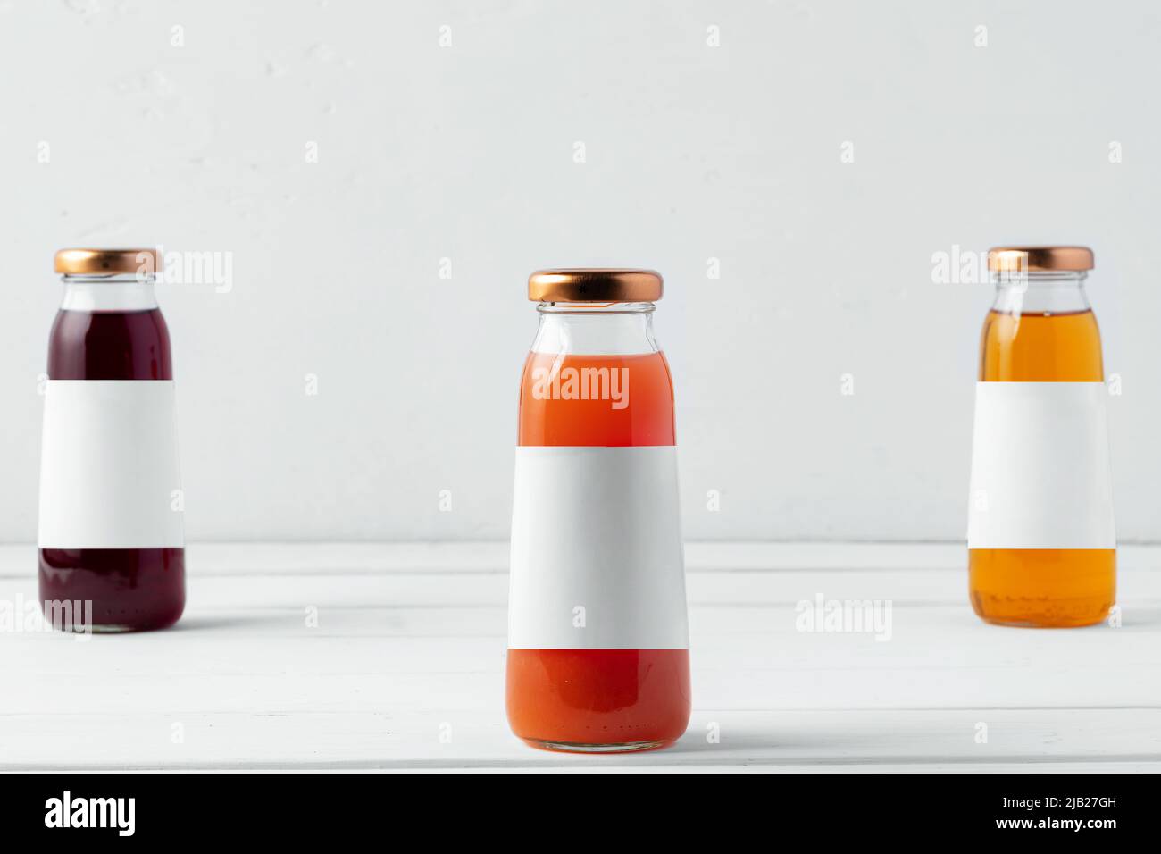 Glass bottles of different juices on white background Stock Photo - Alamy