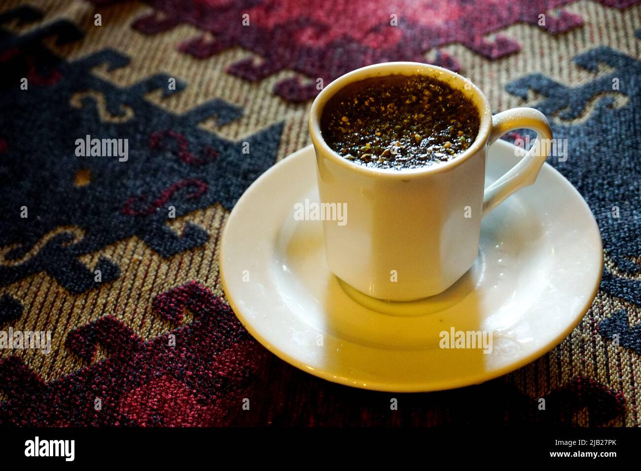 Traditional Menengic coffee on porcelain cup on ethnic table cloth ...
