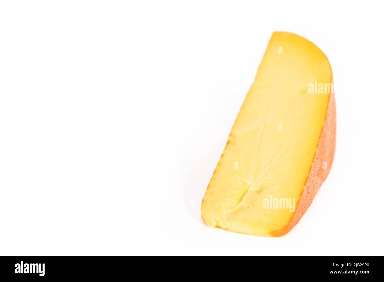 Large slice of smoked gouda cheese on a white background Stock Photo ...