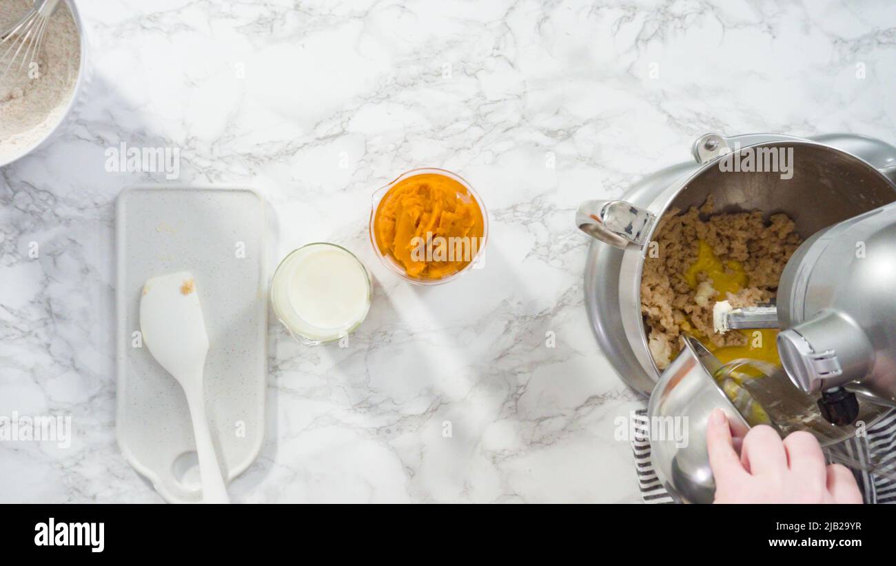 Flat lay. Mixing ingredients in electric kitchen mixer to bake pumpkin ...