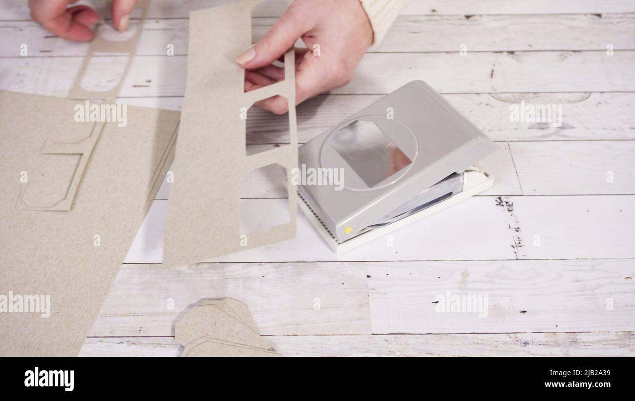 Step by step. Cutting out gift tags from brown paper with a paper punch ...