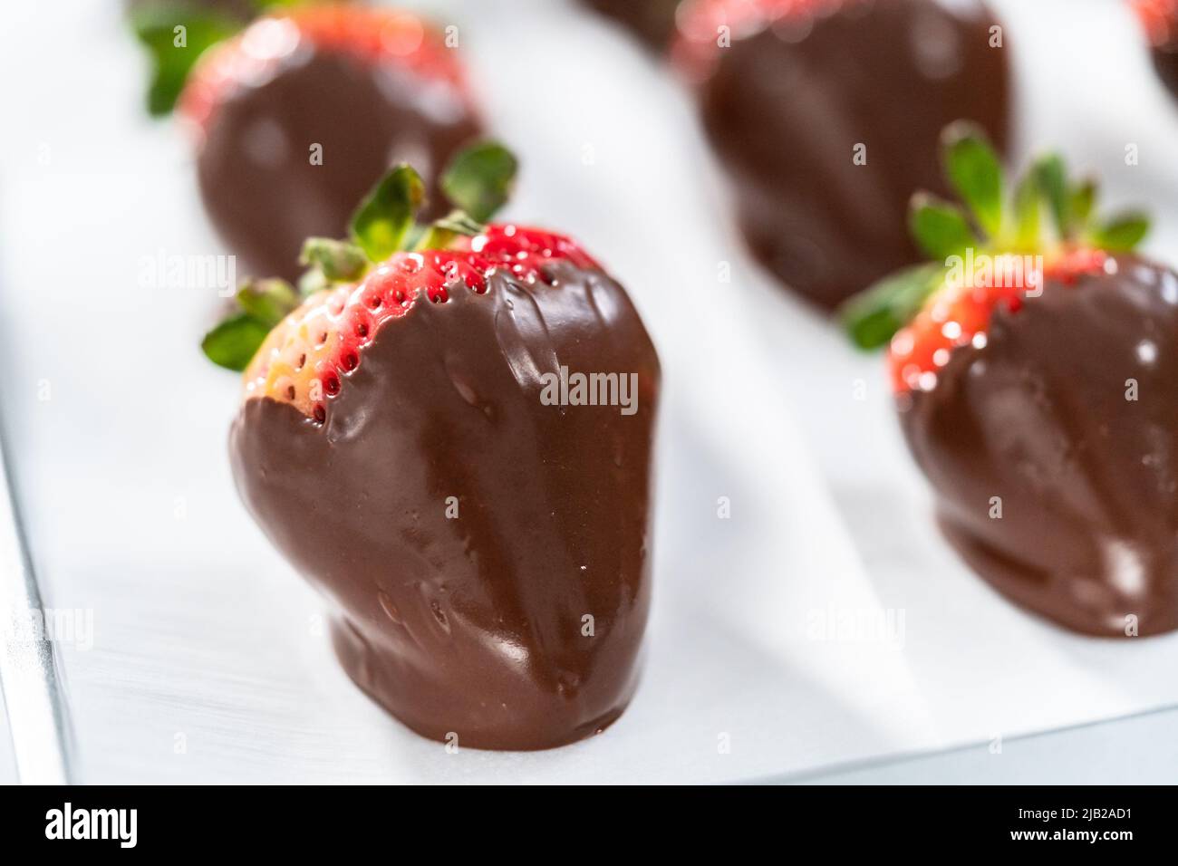 Making white and dark chocolate dipped strawberries Stock Photo - Alamy