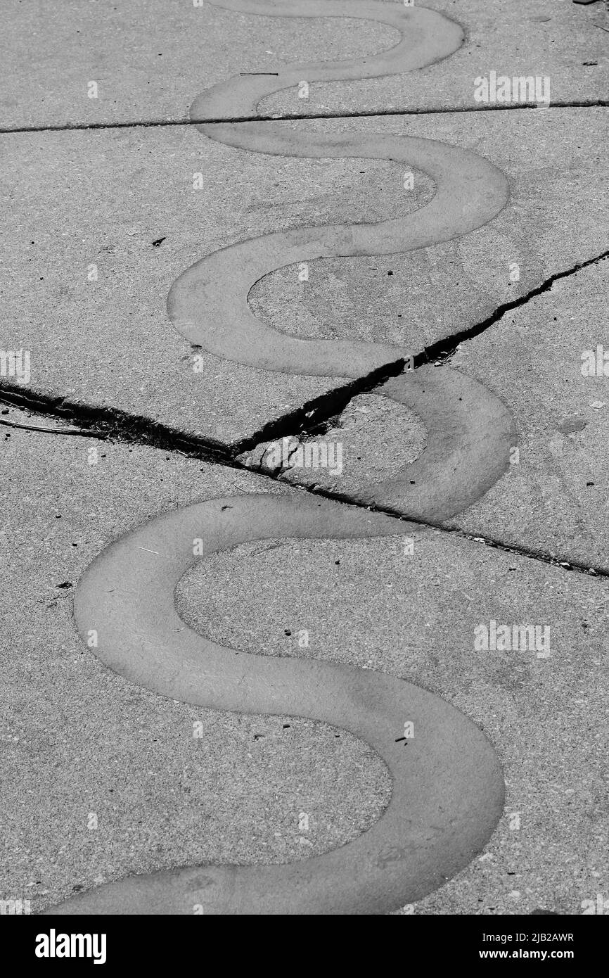 Squiggly wavy and curvy line painted on the concrete sidewalk in black ...