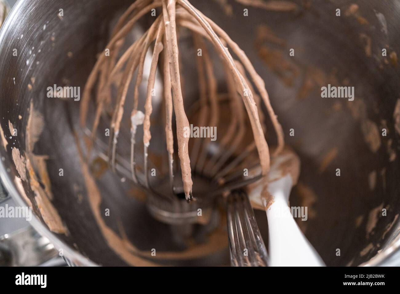 Scooping mixture into the small glass jars to make homemade chocolate ...