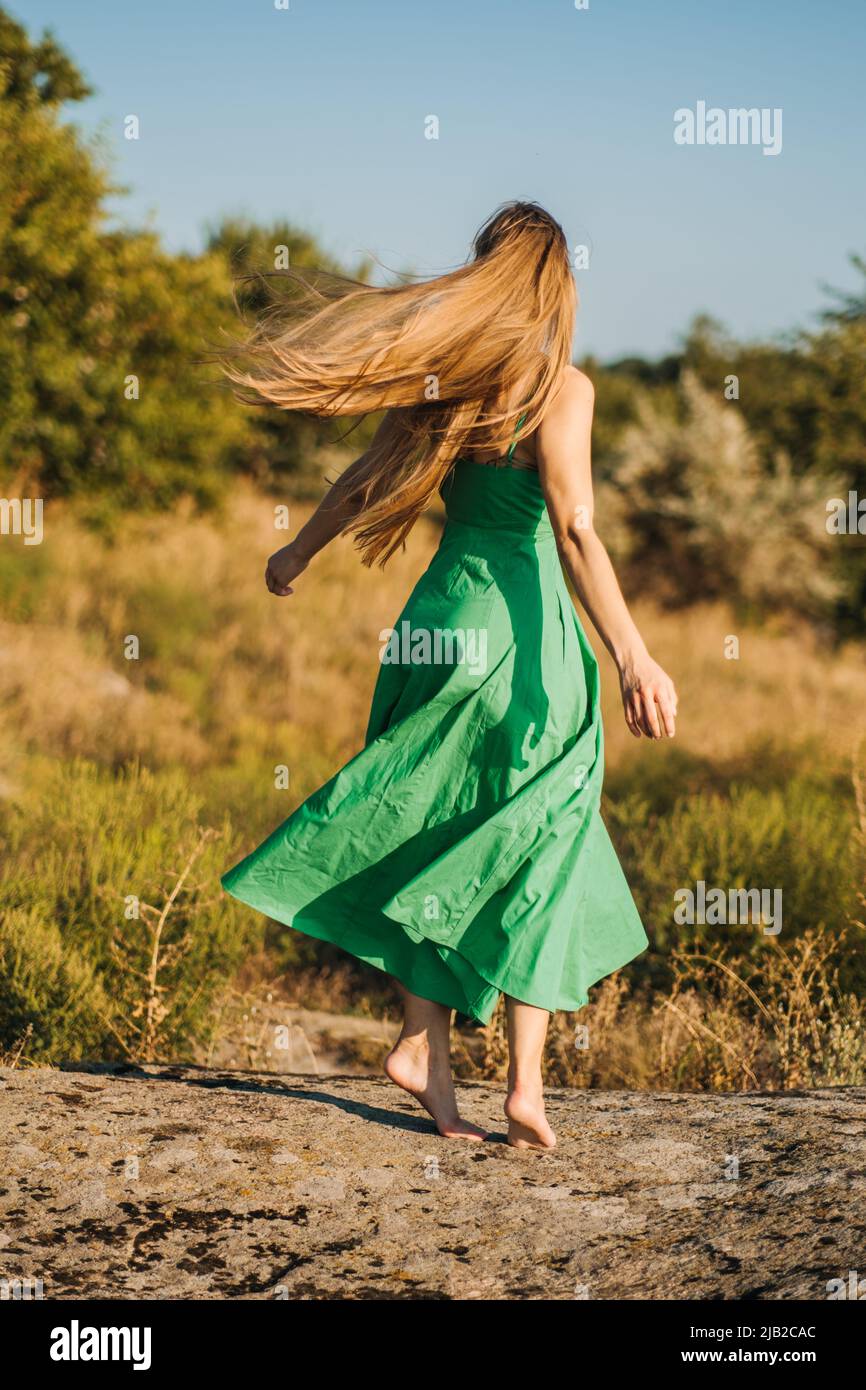 Barefoot Woman in green dress enjoying nature. Nature therapy ...