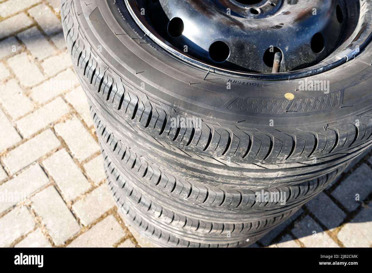 Top view of stacked summer car tires on black steel rims. Selective ...