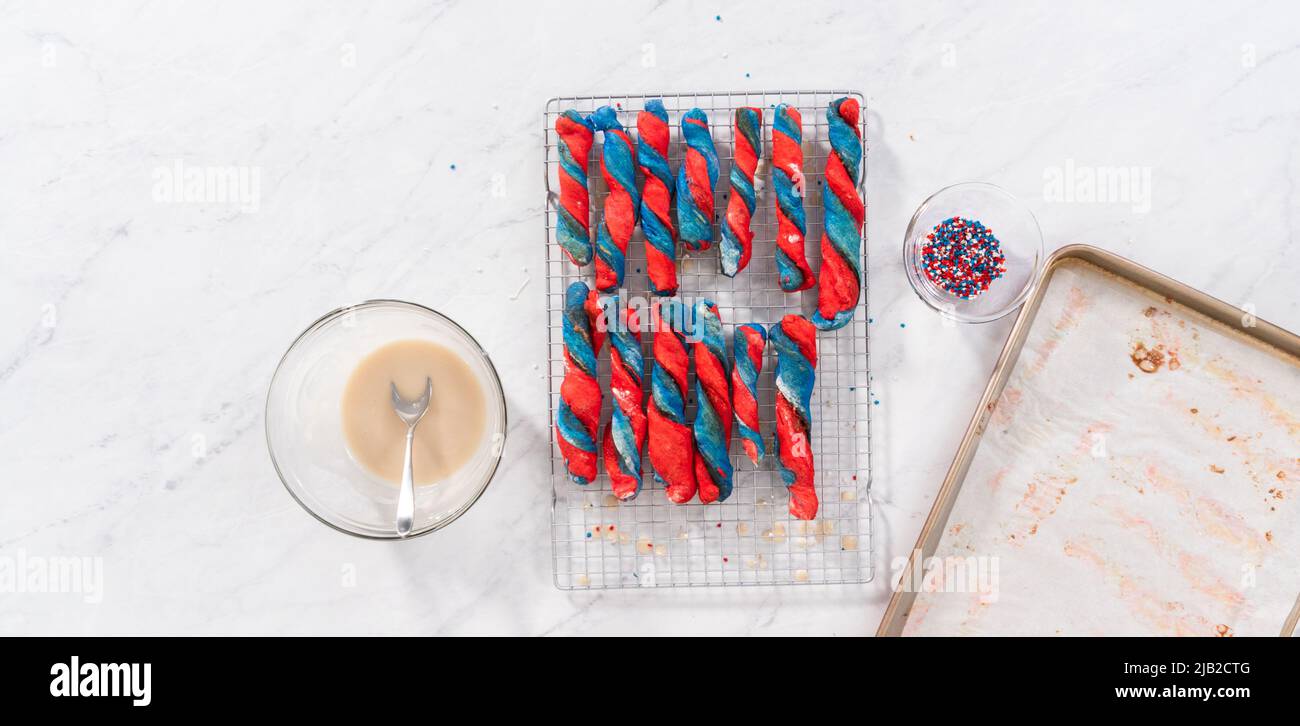 Flat lay. Drizzling white glaze on top of patriotic cinnamon twists and ...