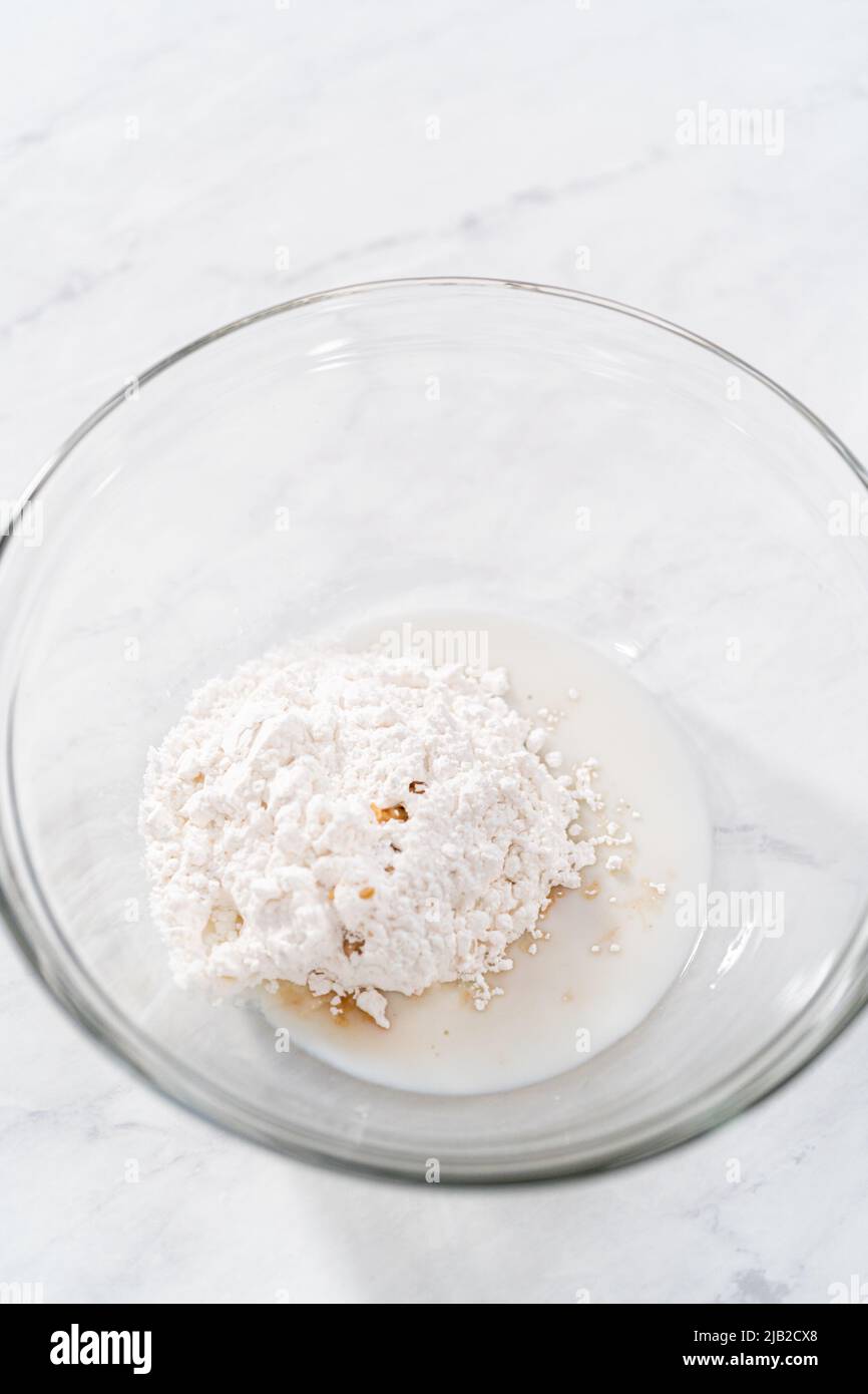 Preparing a white bread glaze in a glass mixing bowl Stock Photo - Alamy