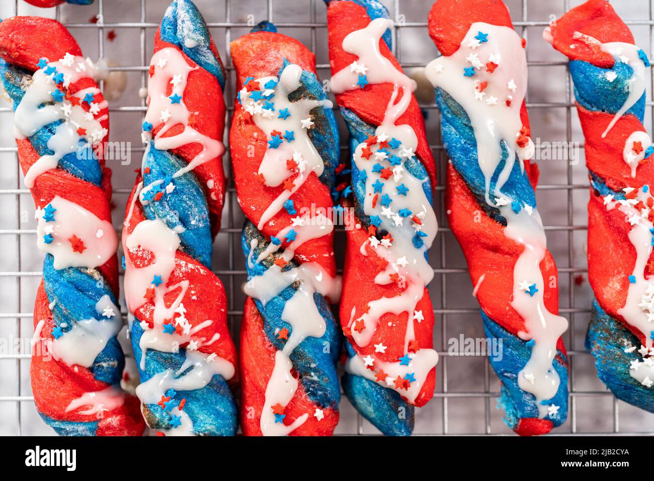 Drizzling white glaze on top of patriotic cinnamon twists and ...