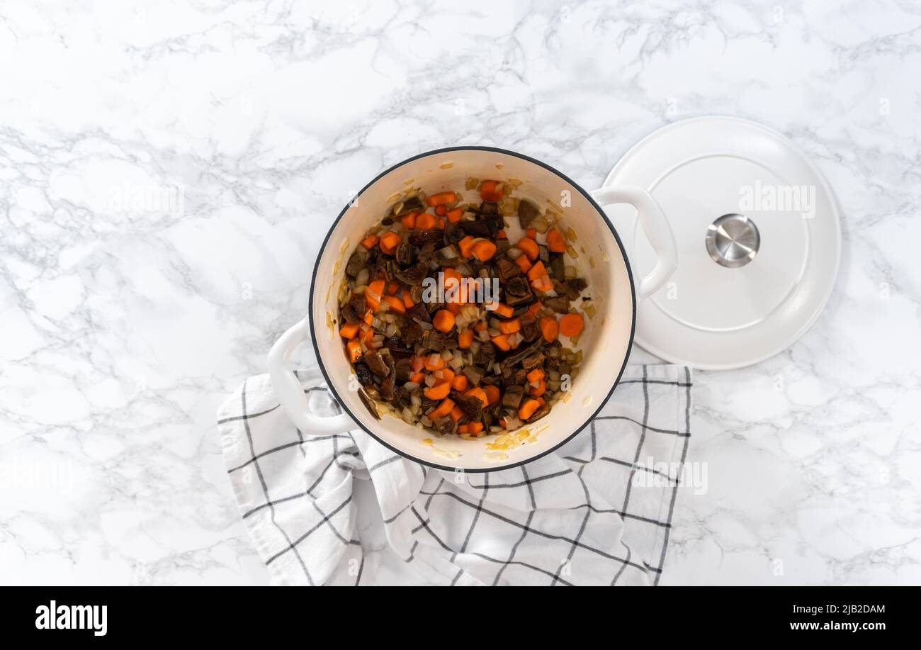 Flat lay. Cooking creamy wild mushroom soup made in an enameled dutch ...