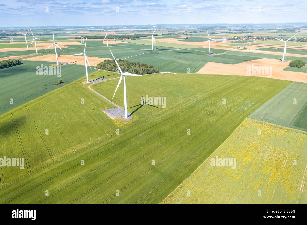 Aerial image of a field, windmills during harvest, and a wind turbine ...