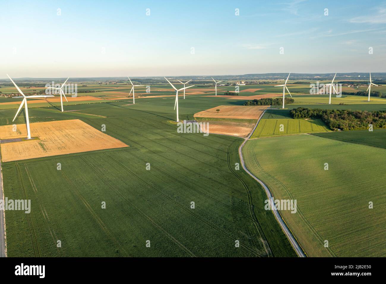 Aerial view of wind turbines in a field of lush, green crops ...