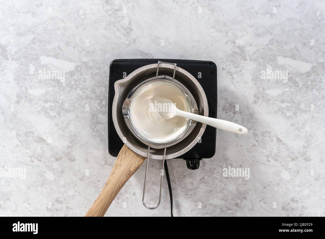 Flat lay. Melting white chocolate chips in a stainless steel double ...