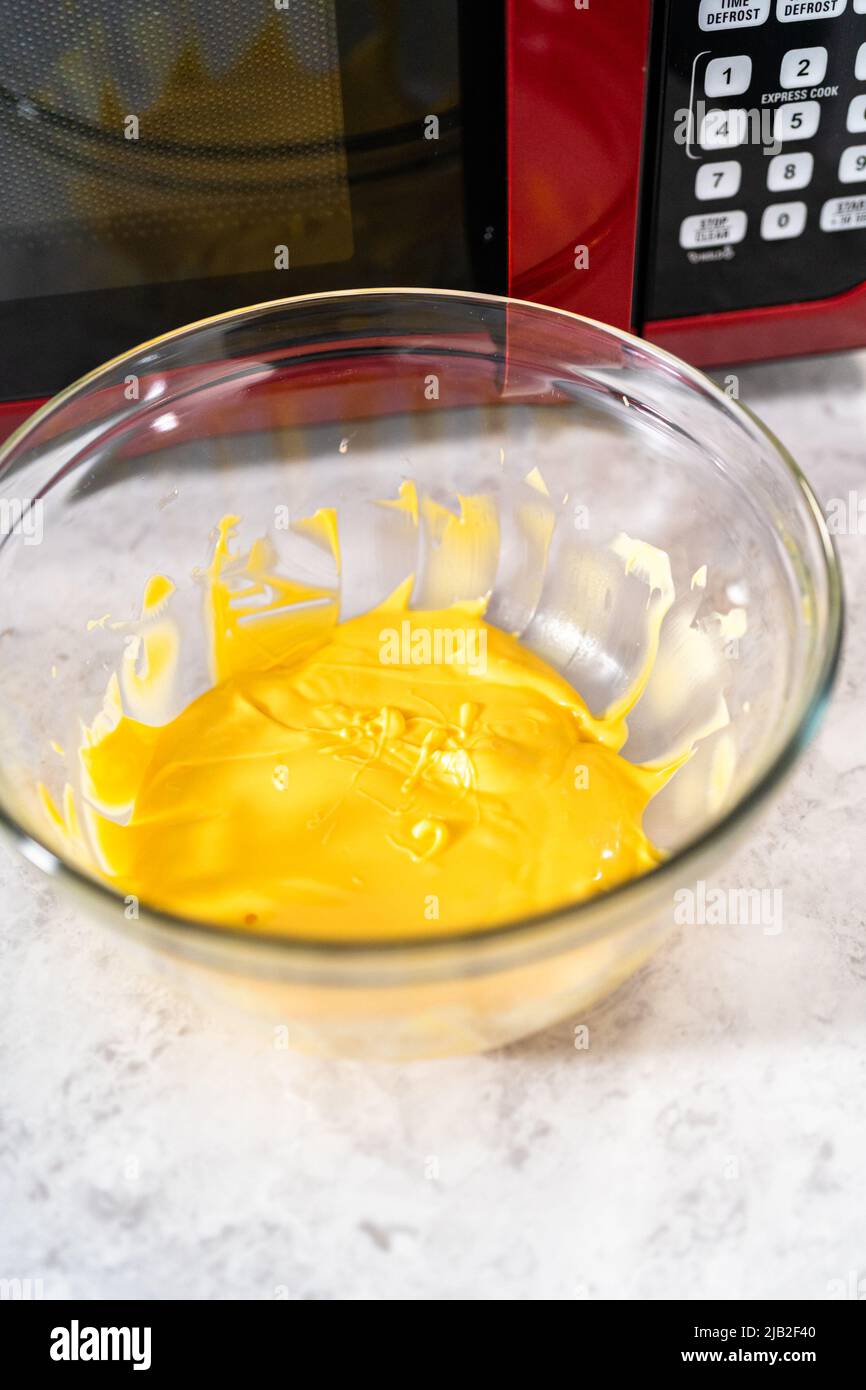 Melting yellow chocolate chips in a glass mixing bowl in a microwave ...