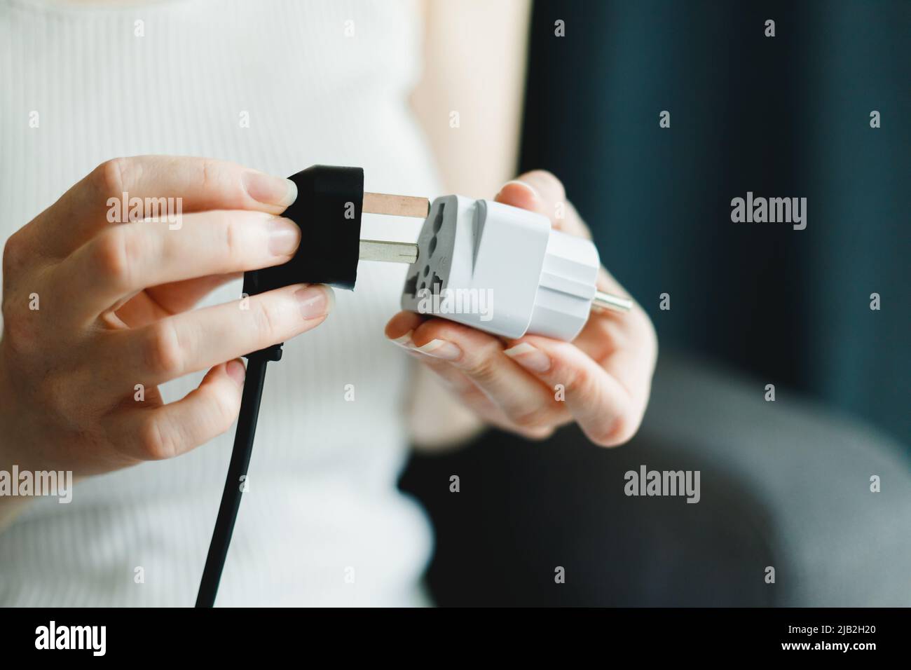 Woman applies universal European plug adapter International AU UK US to ...