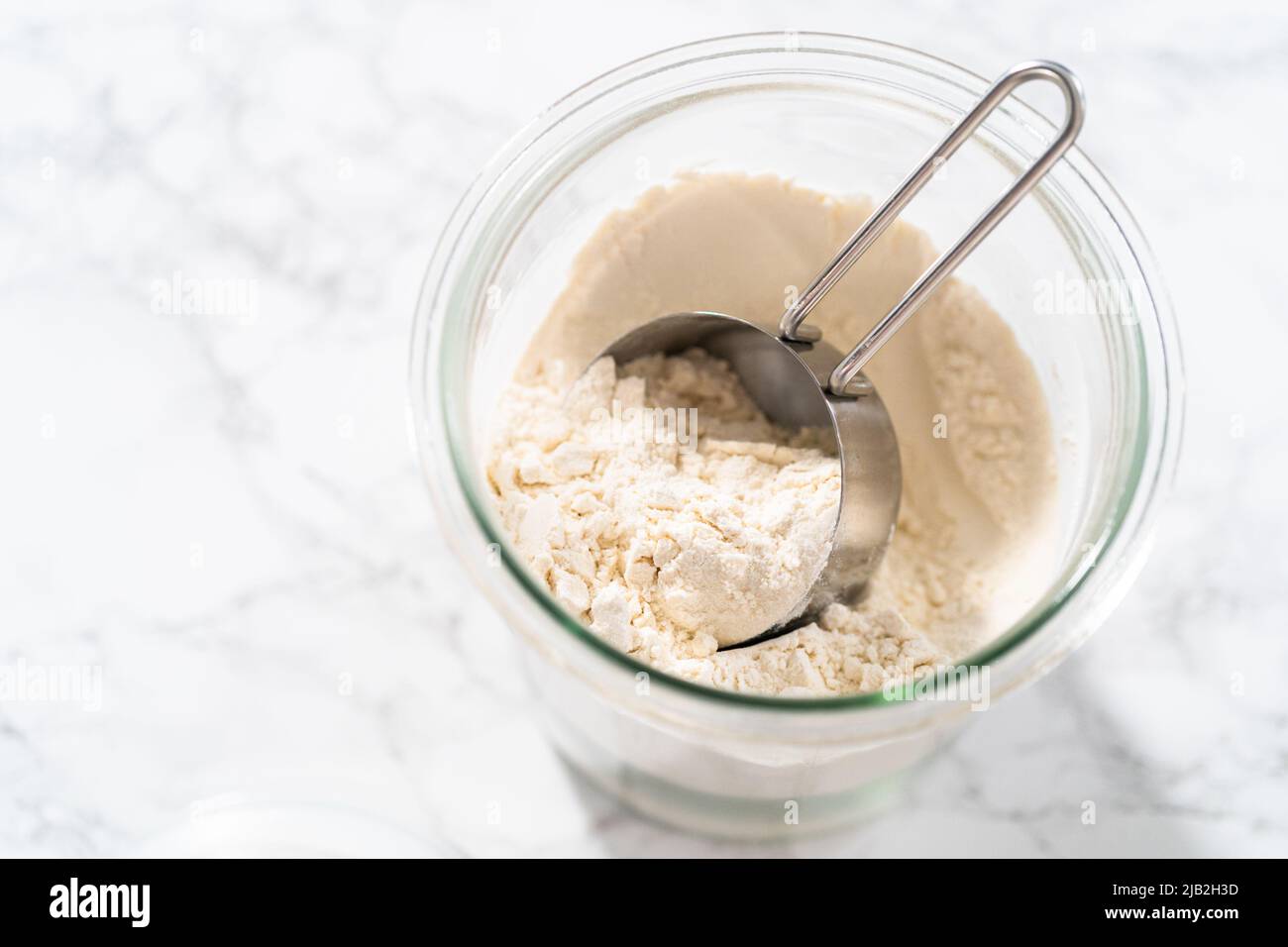 Measuring cup inside glass jar filled with all-purpose flour Stock ...