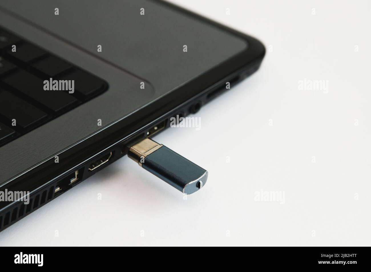 Removable flash disk memory in laptop USB socket on white background ...