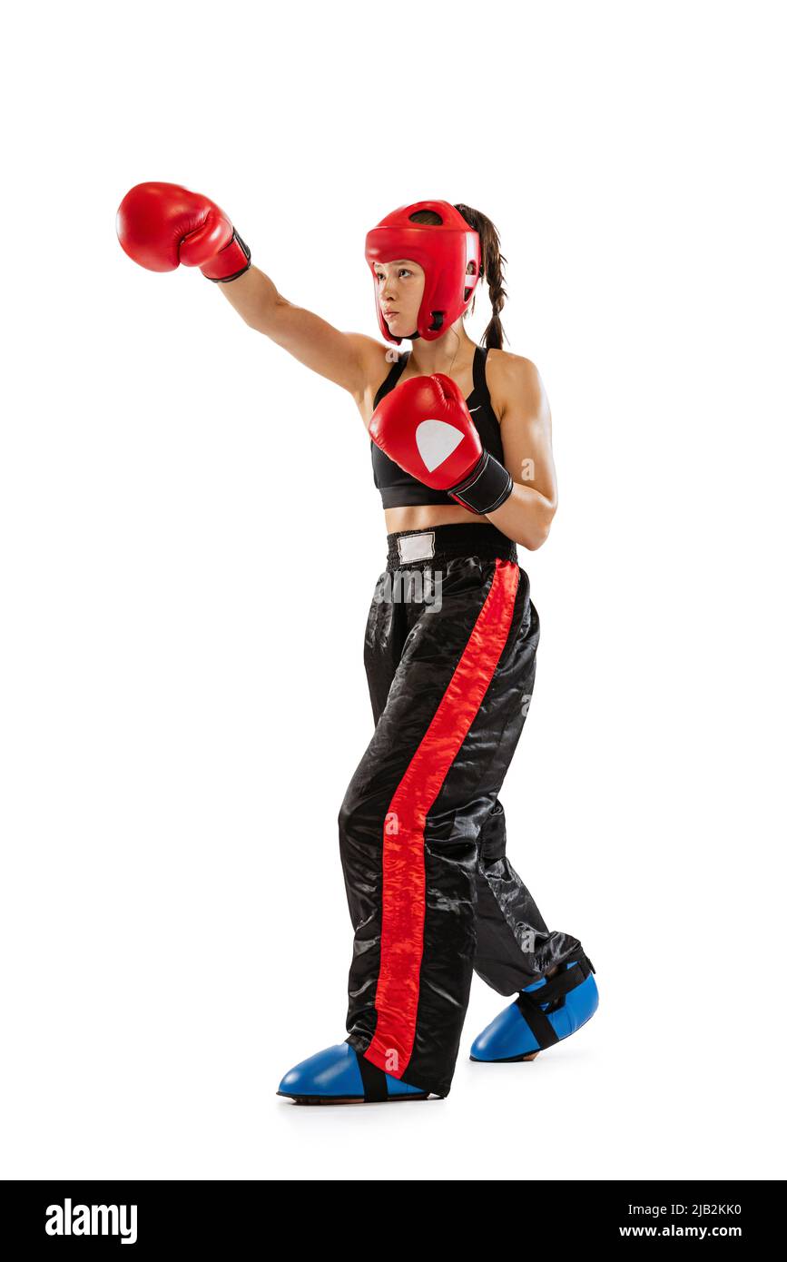 Young female boxer in boxing gloves and helmet training isolated on ...