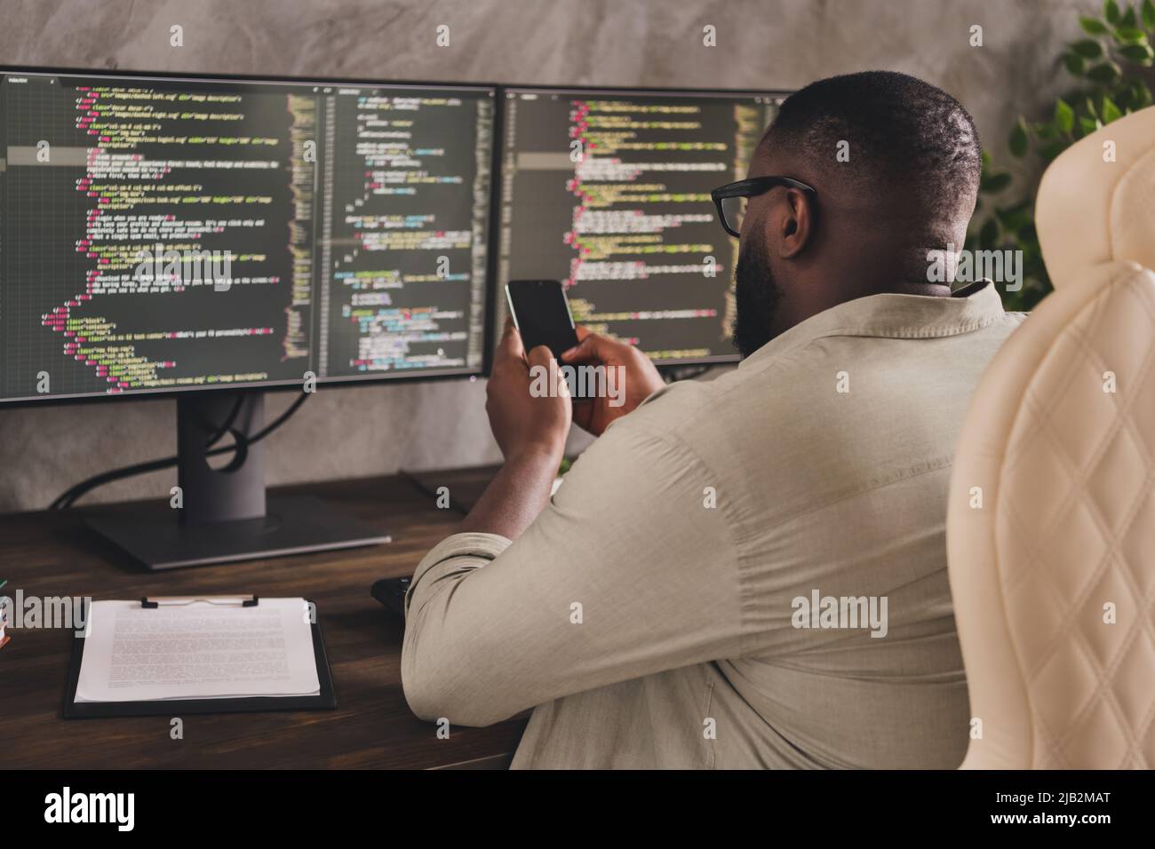 Rear back behind view portrait of handsome focused guy using device ...
