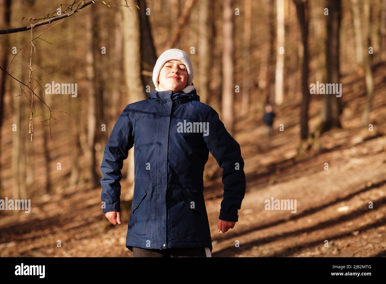 Young boy wear jacket and hat in early spring forest. Inhale fresh air ...