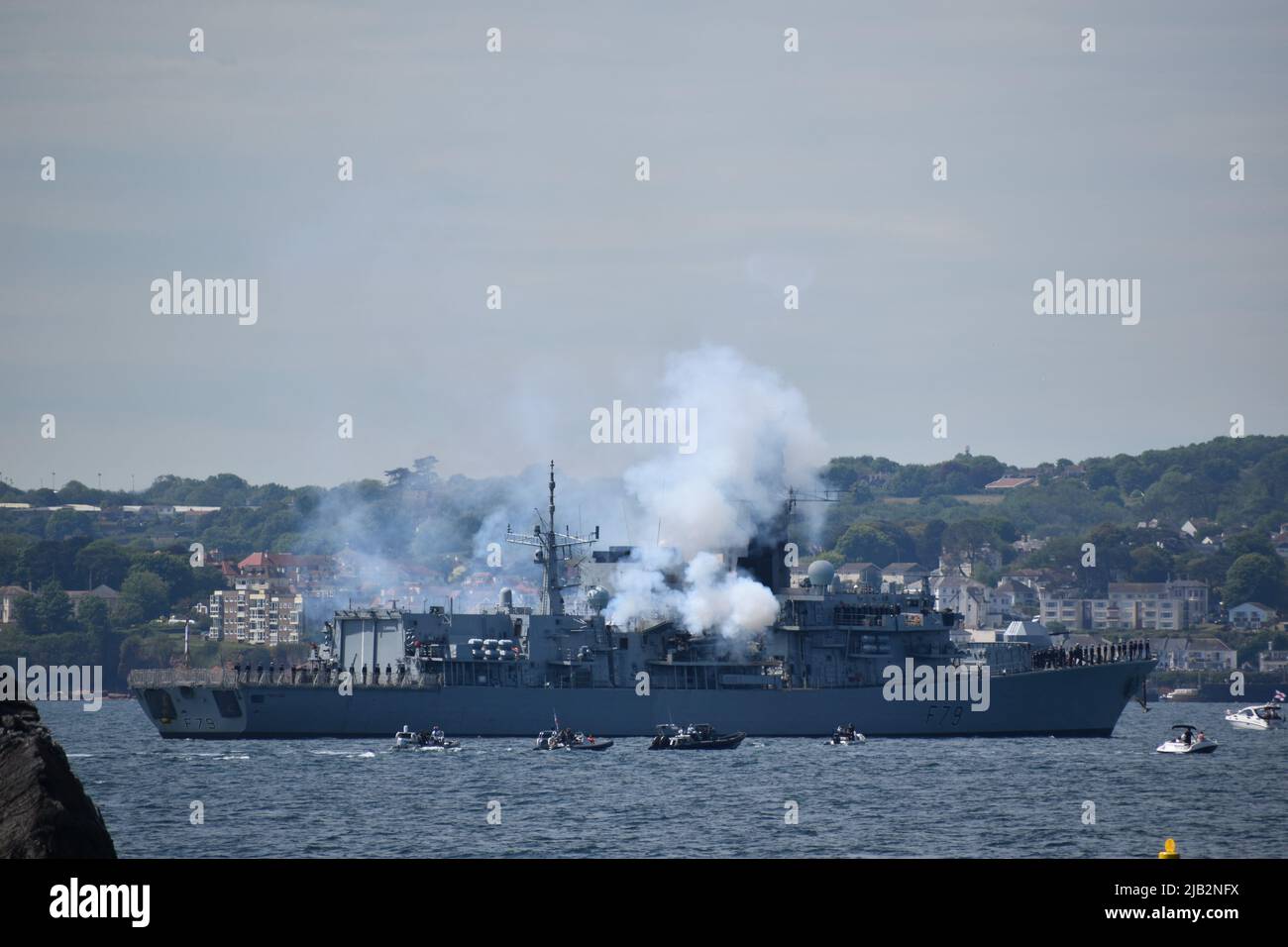 General view of Royal Navy frigate HMS Portland during a gun salute in Tor Bay, Devon, at noon ...