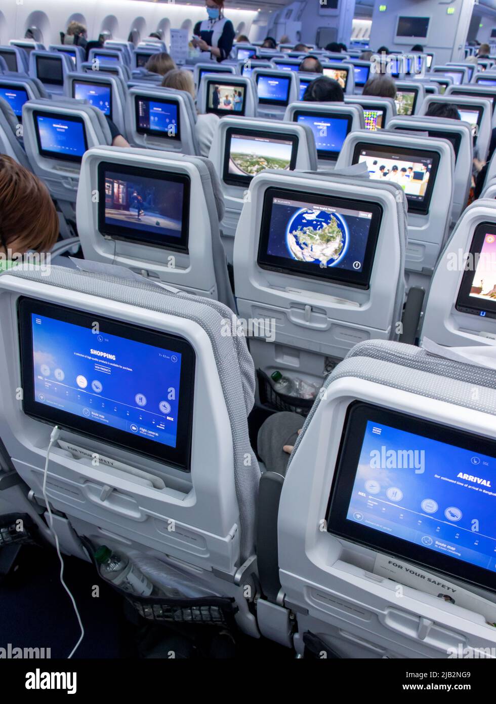 Interior of an flying aircraft with monitors on the seats Stock Photo ...