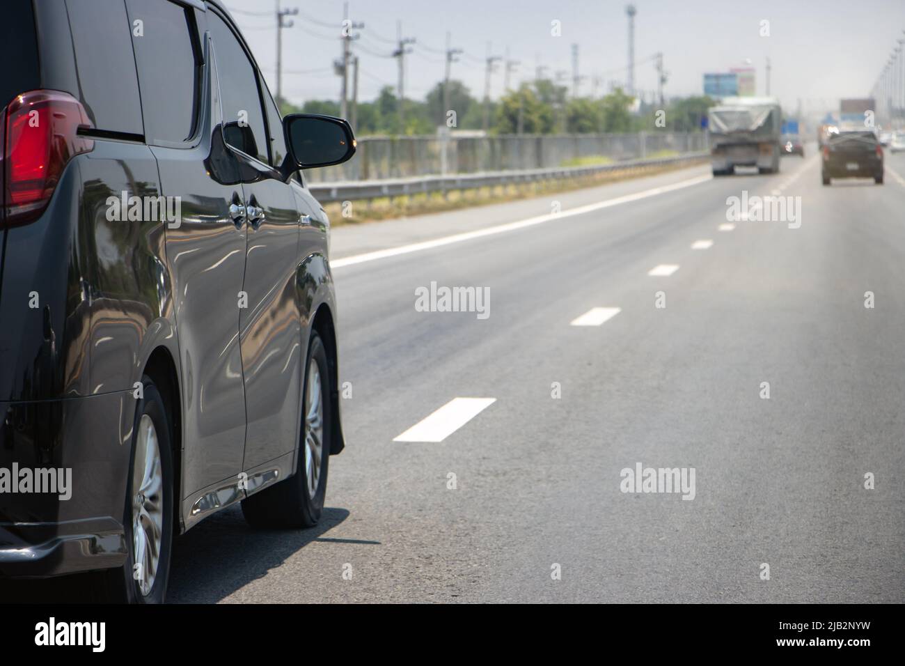 Part of a black minivan driving on the highway Stock Photo - Alamy