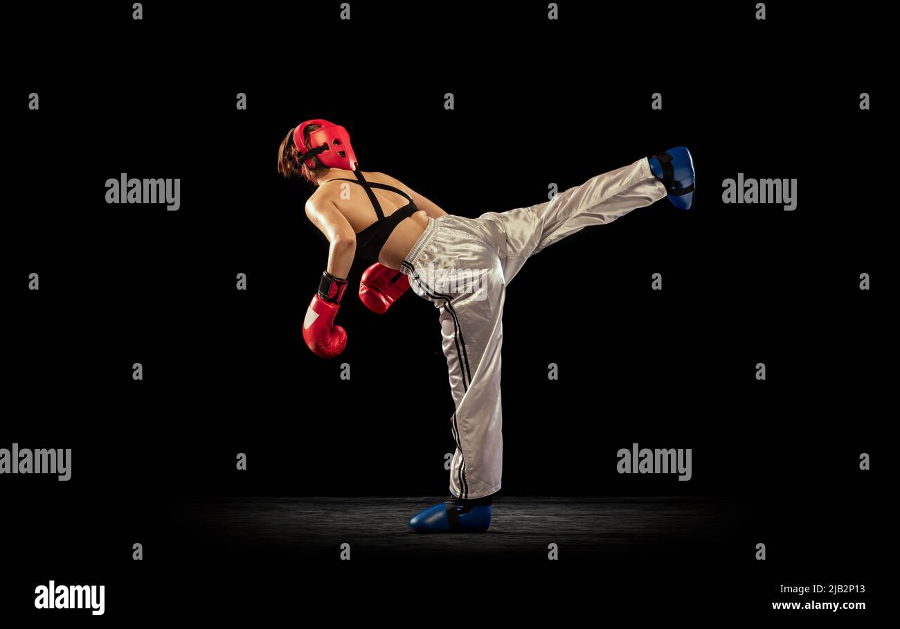Sportive woman, professional boxer in boxing gloves and helmet training ...