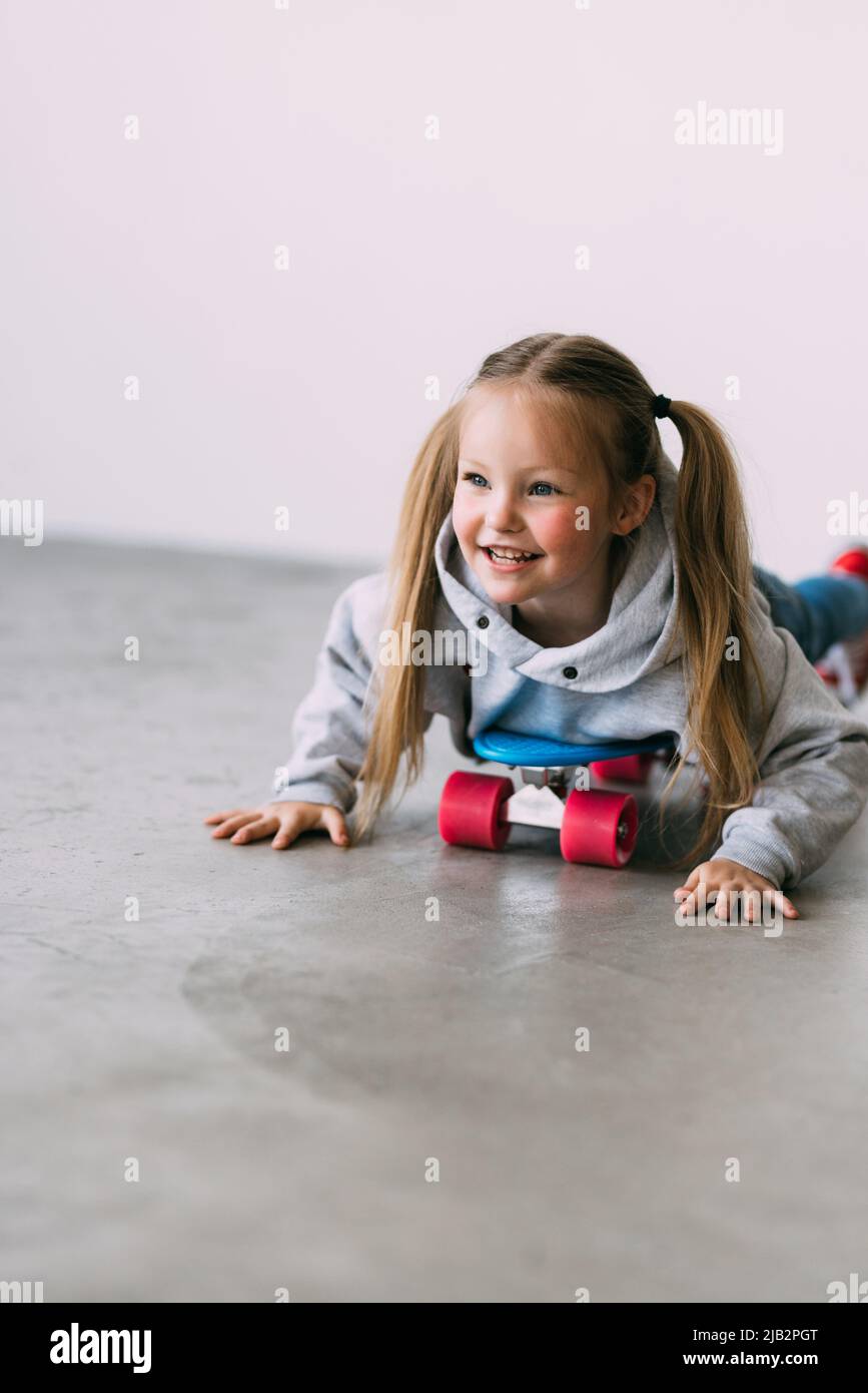 Happy child is riding lying a skateboard like flying indoor Stock Photo ...