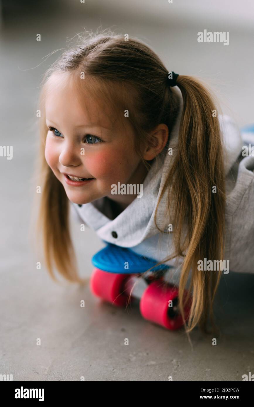 Happy child is riding lying a skateboard like flying indoor Stock Photo ...