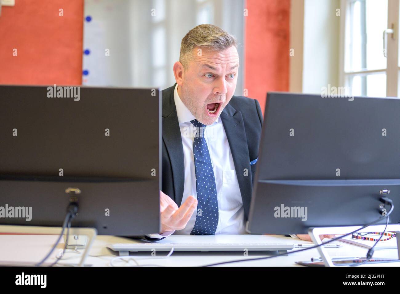 Businessman staring at his computer with stupefication and his mouth ...