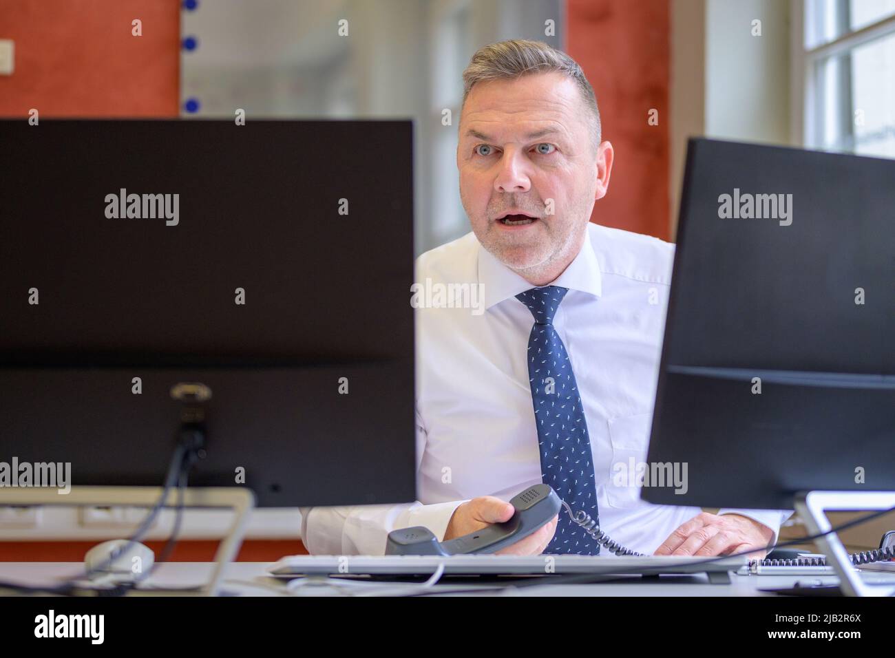 Speechless businessman staring at his monitor in wide eyed shock with ...