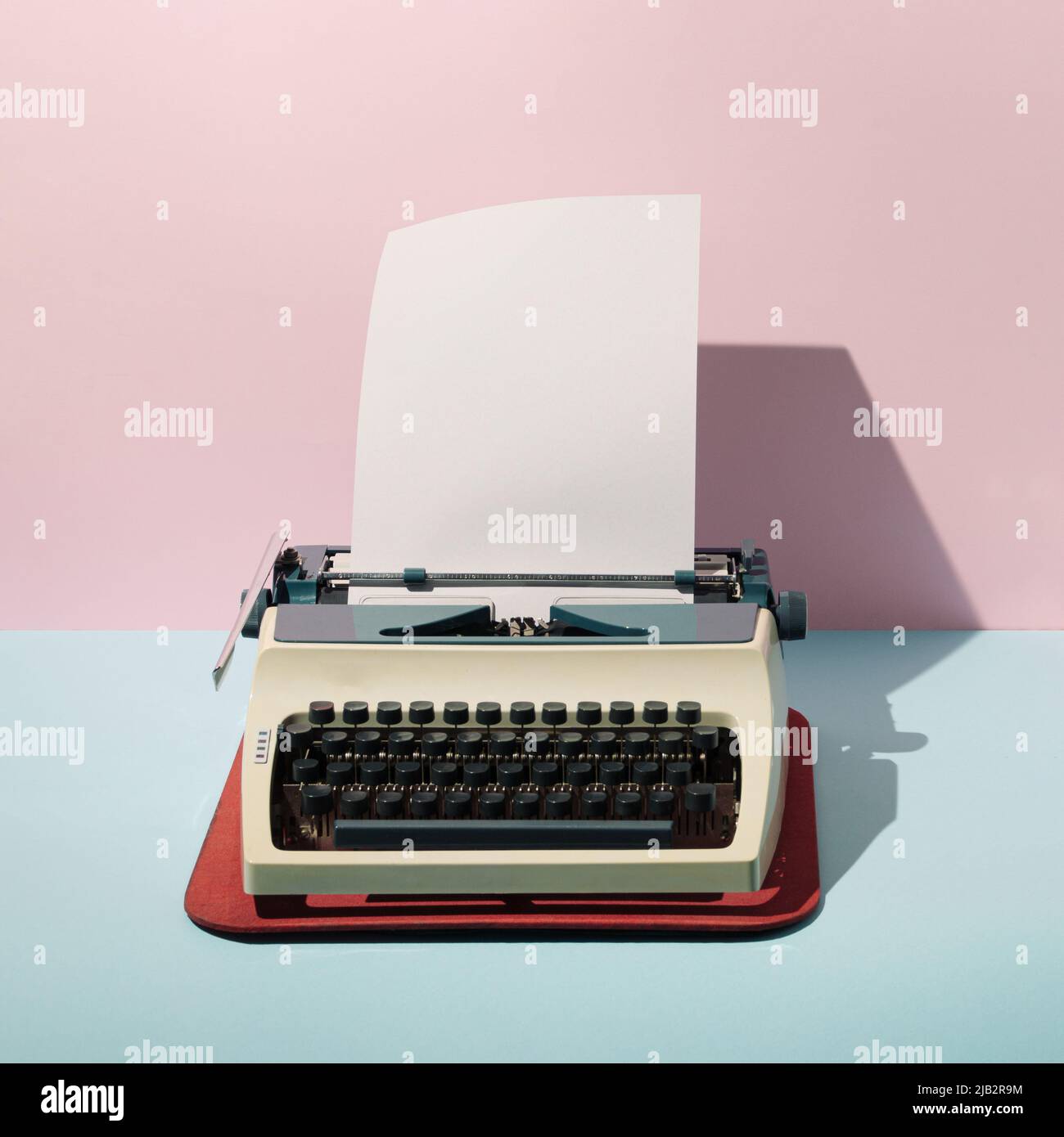 Pastel pink and blue background against retro vintage typing machine ...