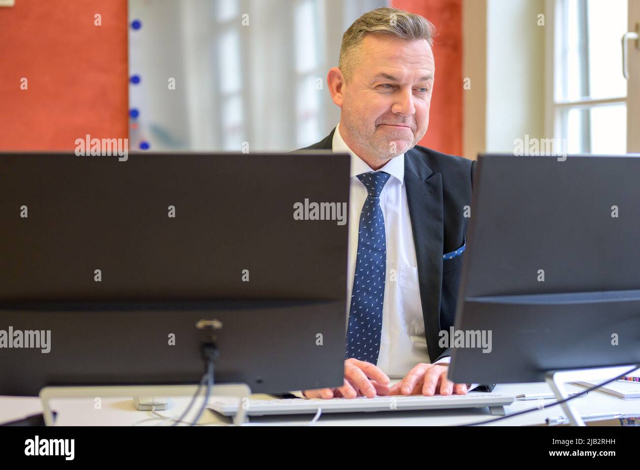 Businessman looking at his computer in satisfaction giving a quiet ...