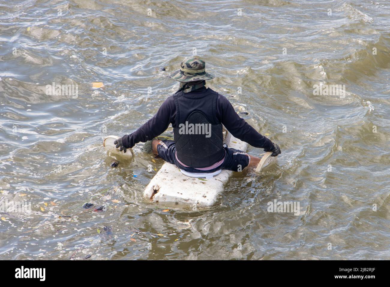 A man floating on a polystyrene and used a lids for paddled Stock Photo ...