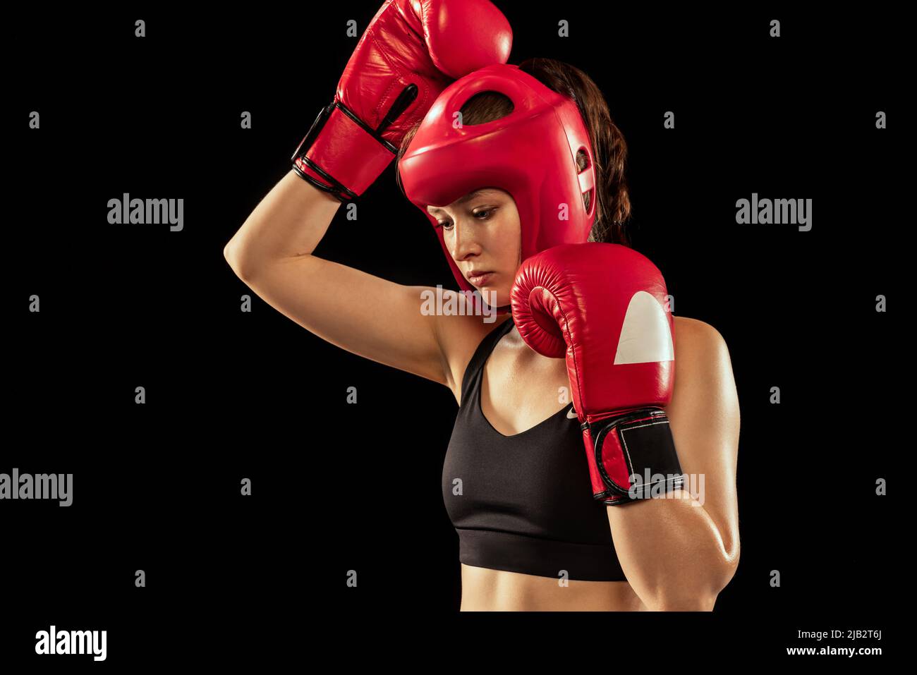 Half-length portrait of professional female boxer in sports protective ...