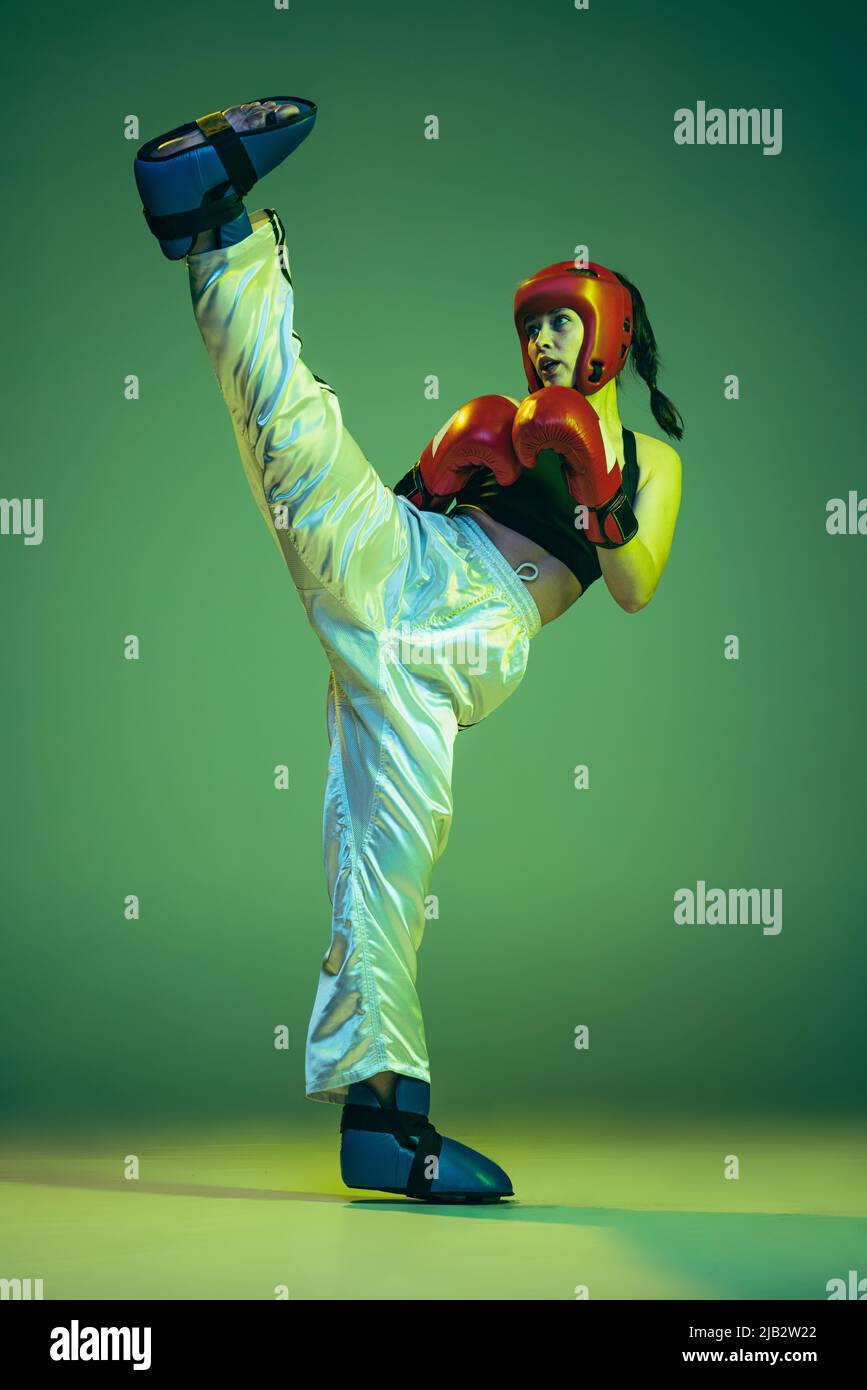 Professional female boxer in boxing gloves and helmet in action, motion ...