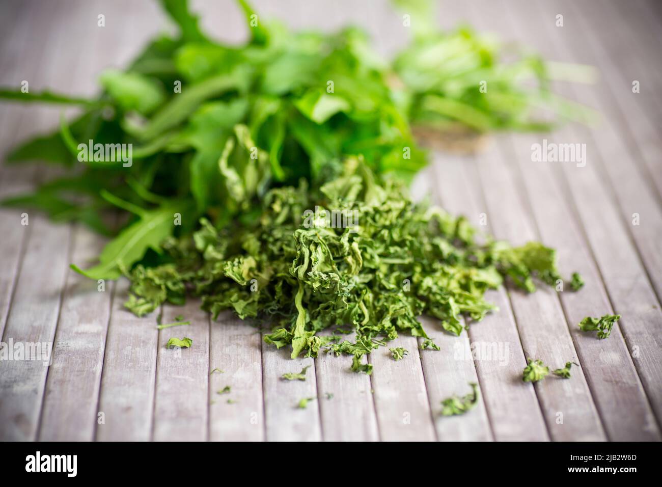 dried green organic arugula, seasoning, on wooden table Stock Photo - Alamy