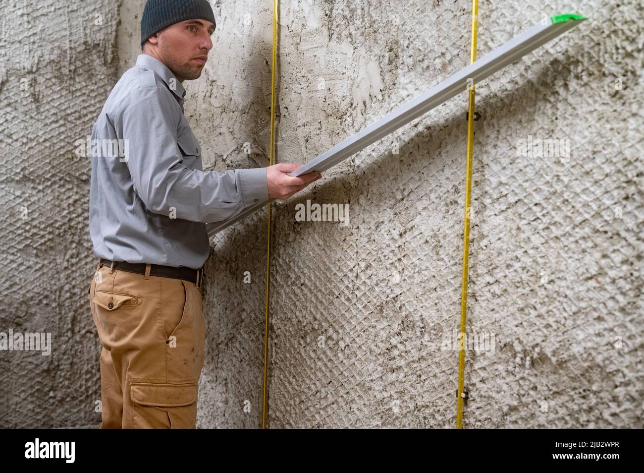 metal guide beacons are attached to the wall, the master checks the ...