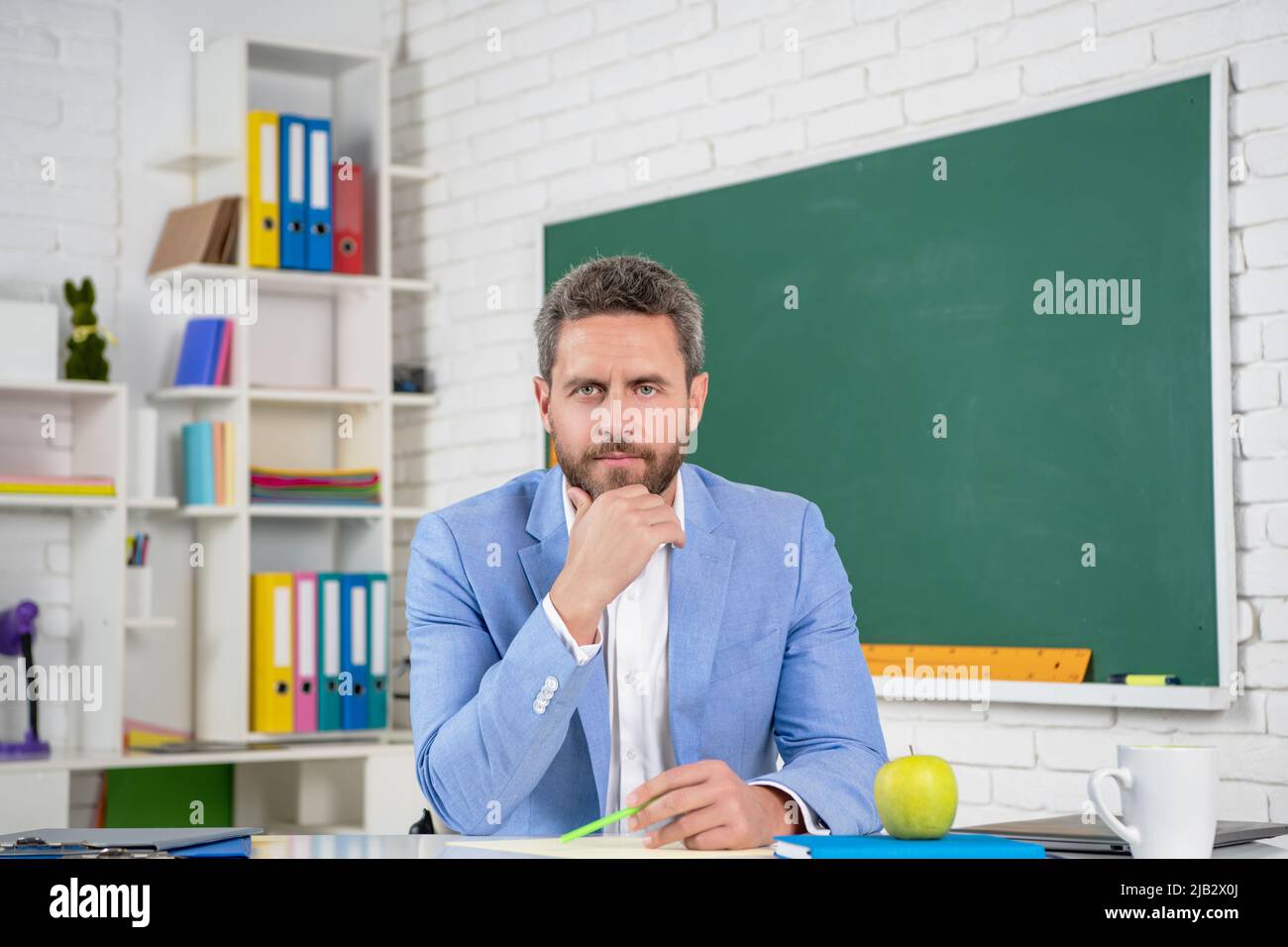 serious school teacher in classroom at blackboard Stock Photo - Alamy