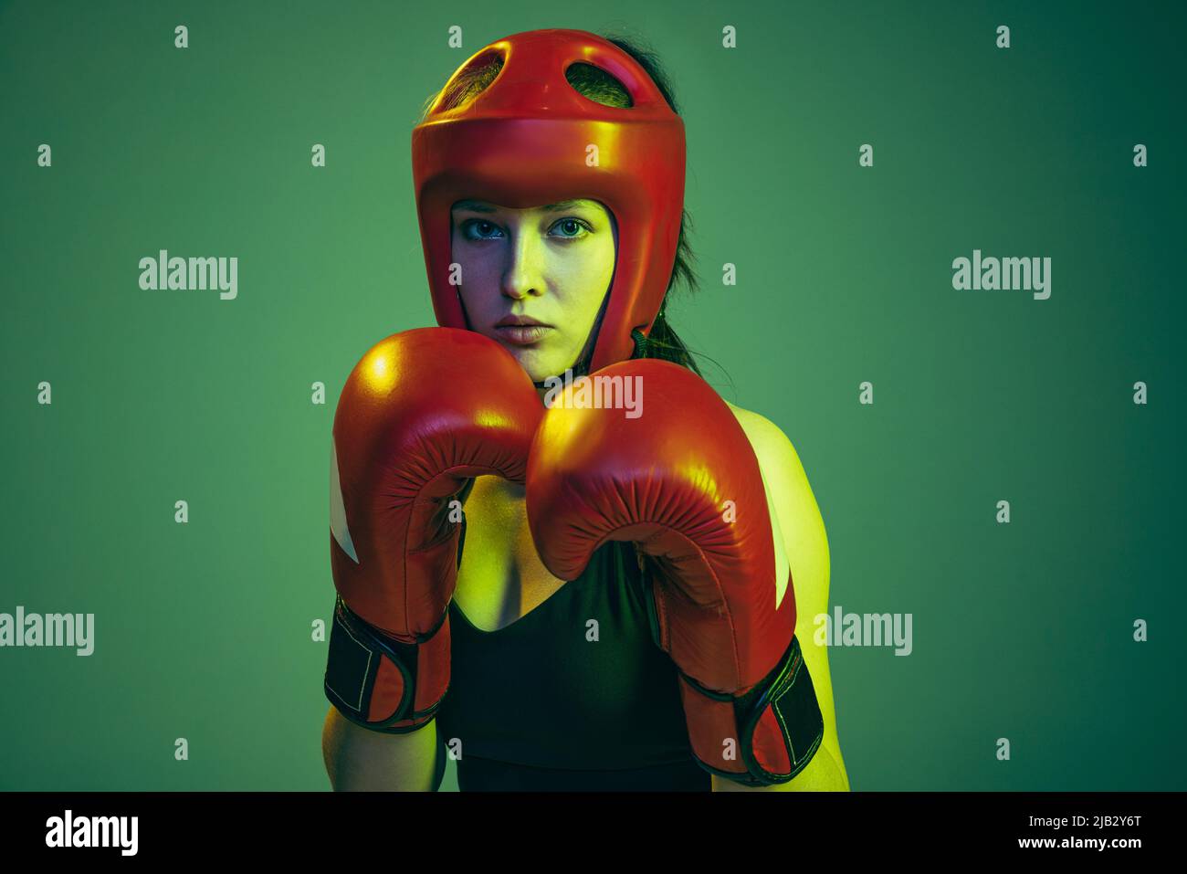 Portrait of beautiful girl, female boxer in sports protective equipment ...