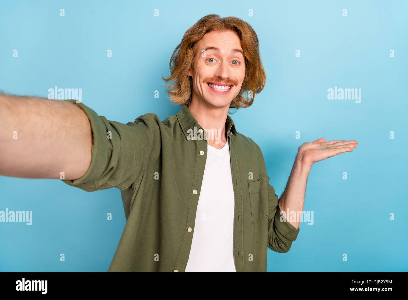 Self-portrait of attractive cheerful funky guy holding on palmcopy ...