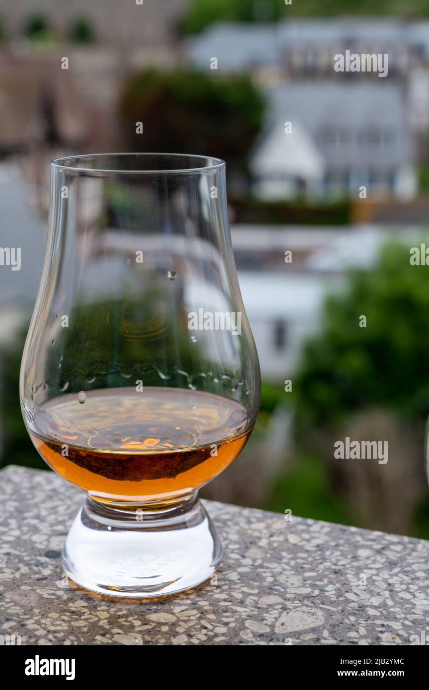 Dram of scotch whiskey with view on old houses on background, Edinburgh ...