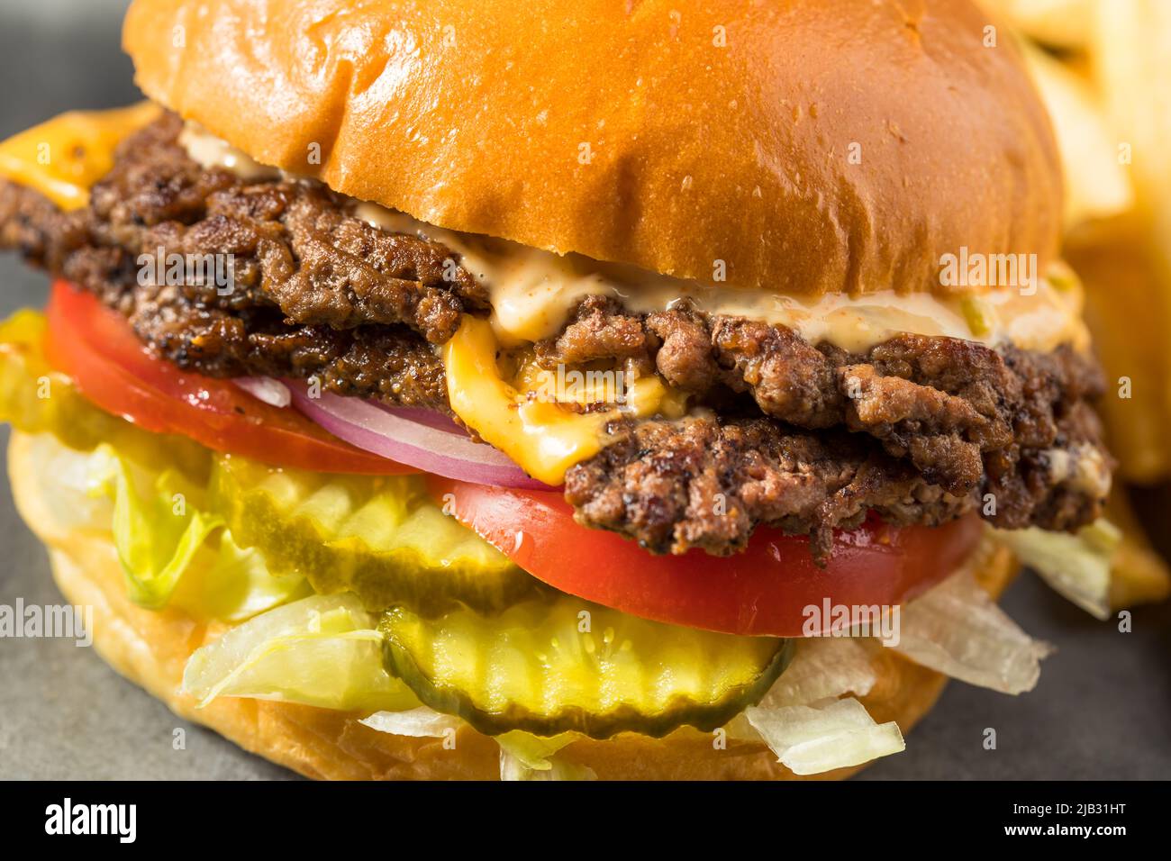 Homemade Cheese Smash Burger with Fries Pickles and Tomatoes Stock ...